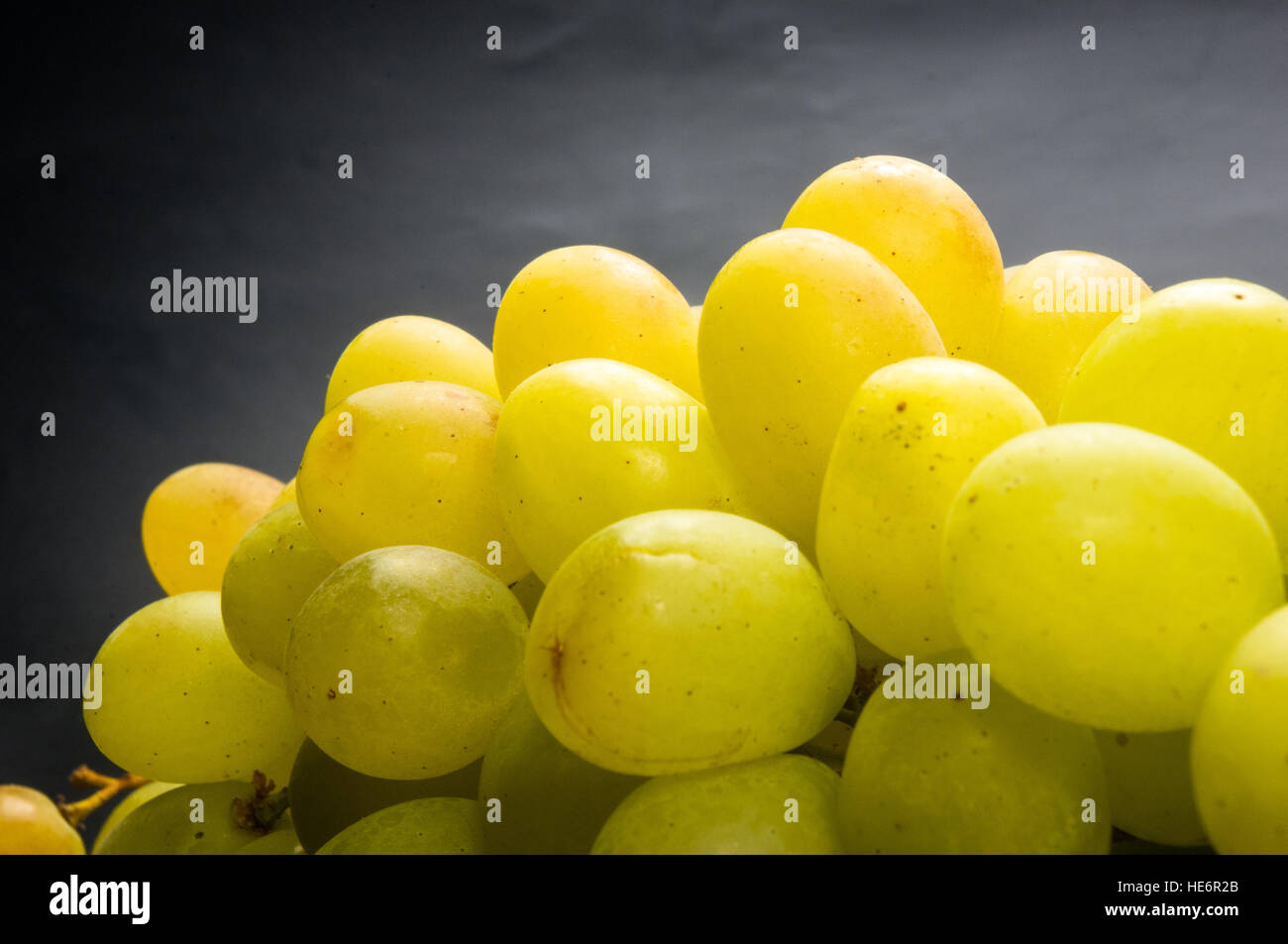 Large grapes cluster amber color on black background Stock Photo - Alamy