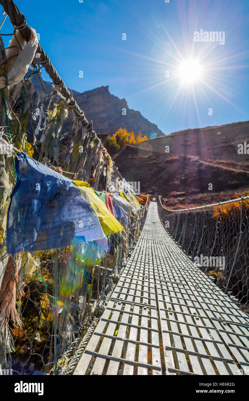 Metal suspension bridge with buddhist praying flags Stock Photo - Alamy