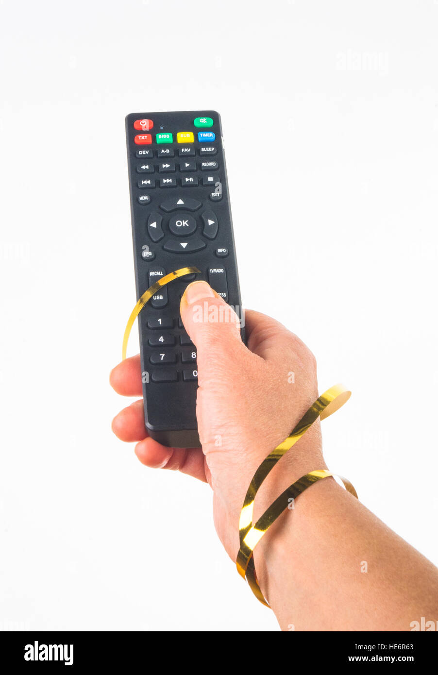 hand holding a remote control in a festive gold ribbon on white ...