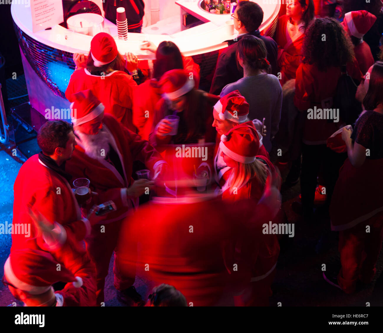 Christmas party santas enjoying a drink at the bar Stock Photo - Alamy