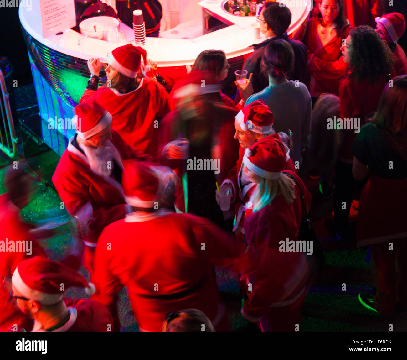 Christmas party santas enjoying a drink at the bar Stock Photo - Alamy
