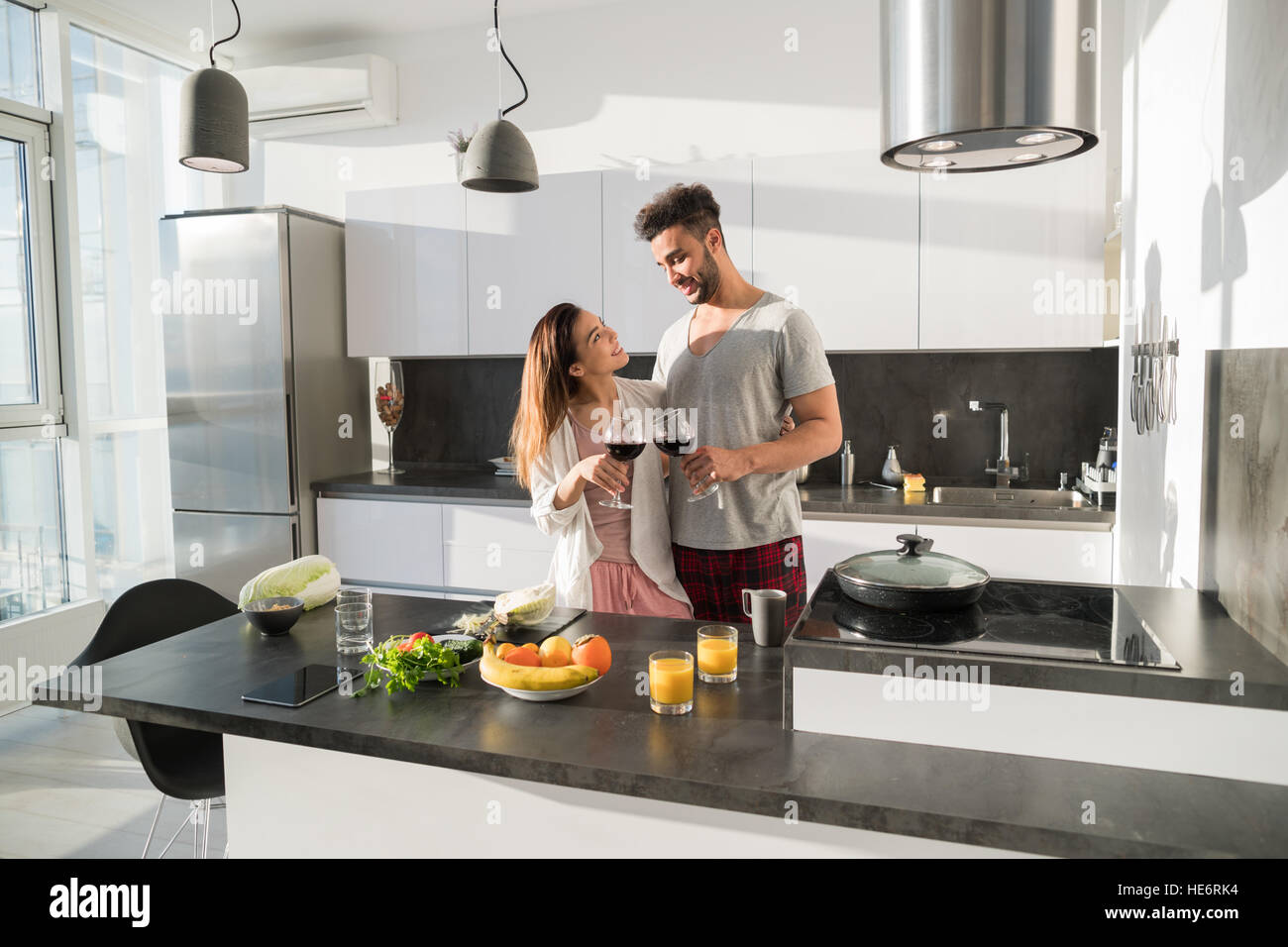 Young Couple Embrace In Kitchen, Hispanic Man And Asian Woman Hug Drink ...