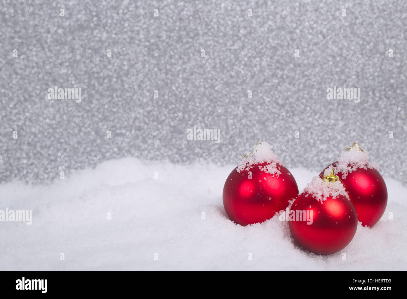 Red christmas balls in snow on glitter background Stock Photo - Alamy