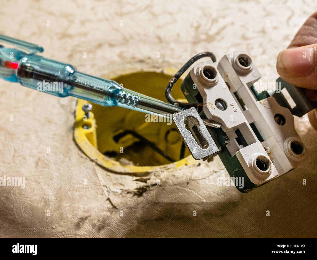 Hand holding a screwdriver pointing at a damaged electric socket Stock ...
