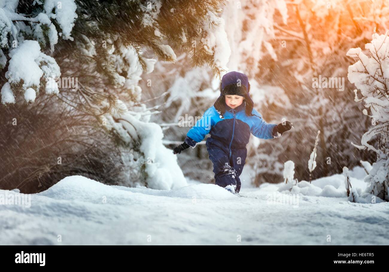 Boy playing in big snow in winter. Happy caucasian child playing in ...