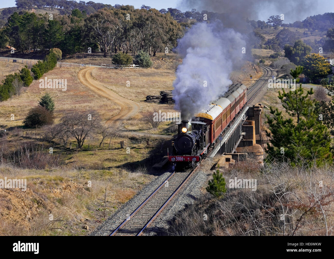 Vintage steam train travels through countryside over bridge Stock Photo ...