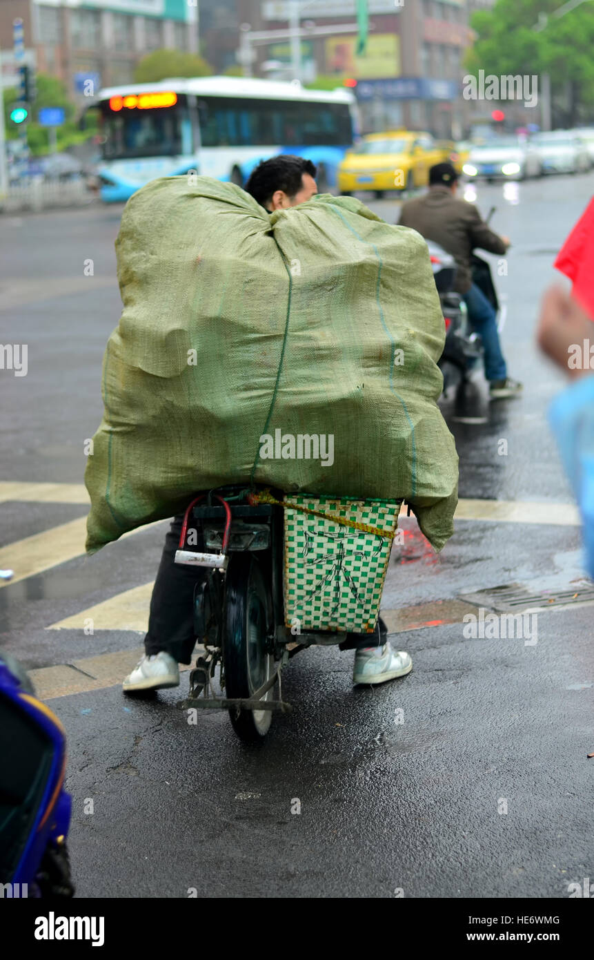 A man carrying an over loaded carriage Stock Photo - Alamy