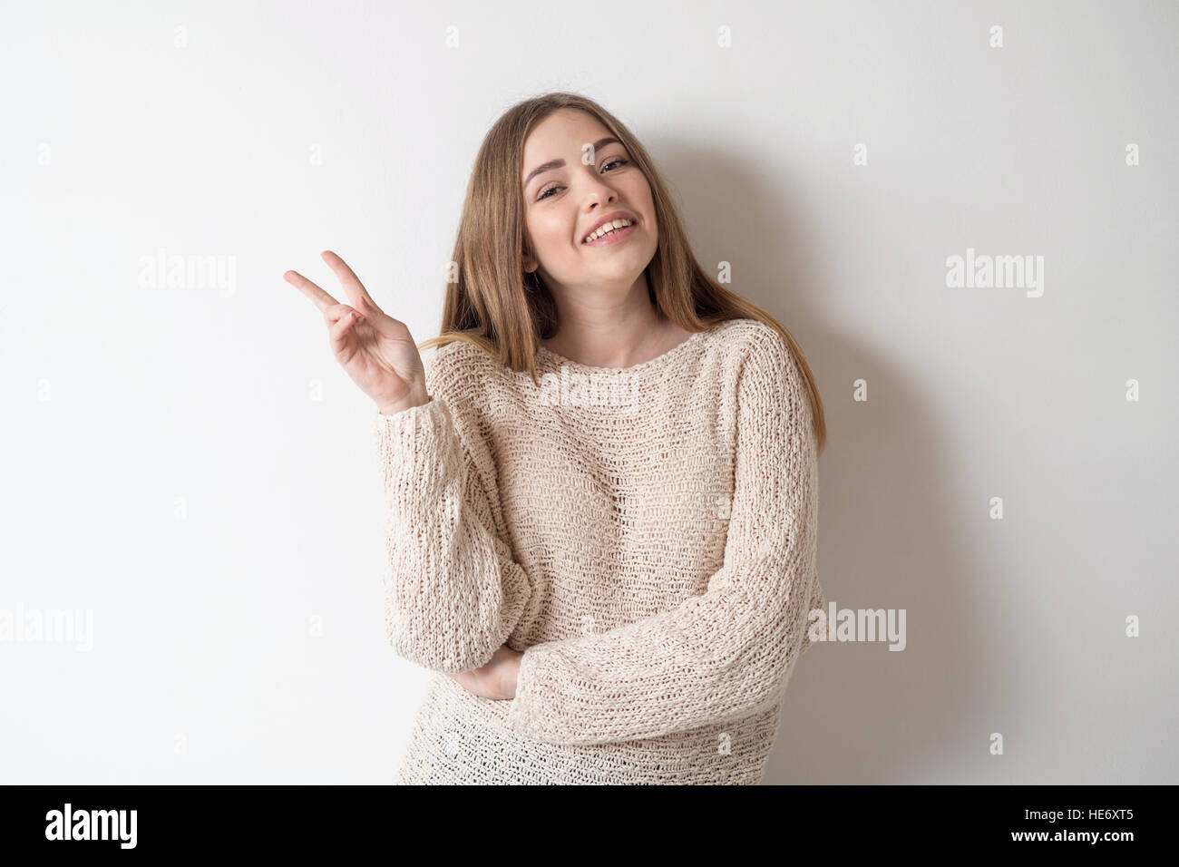 Funny girl showing the peace sign Stock Photo - Alamy