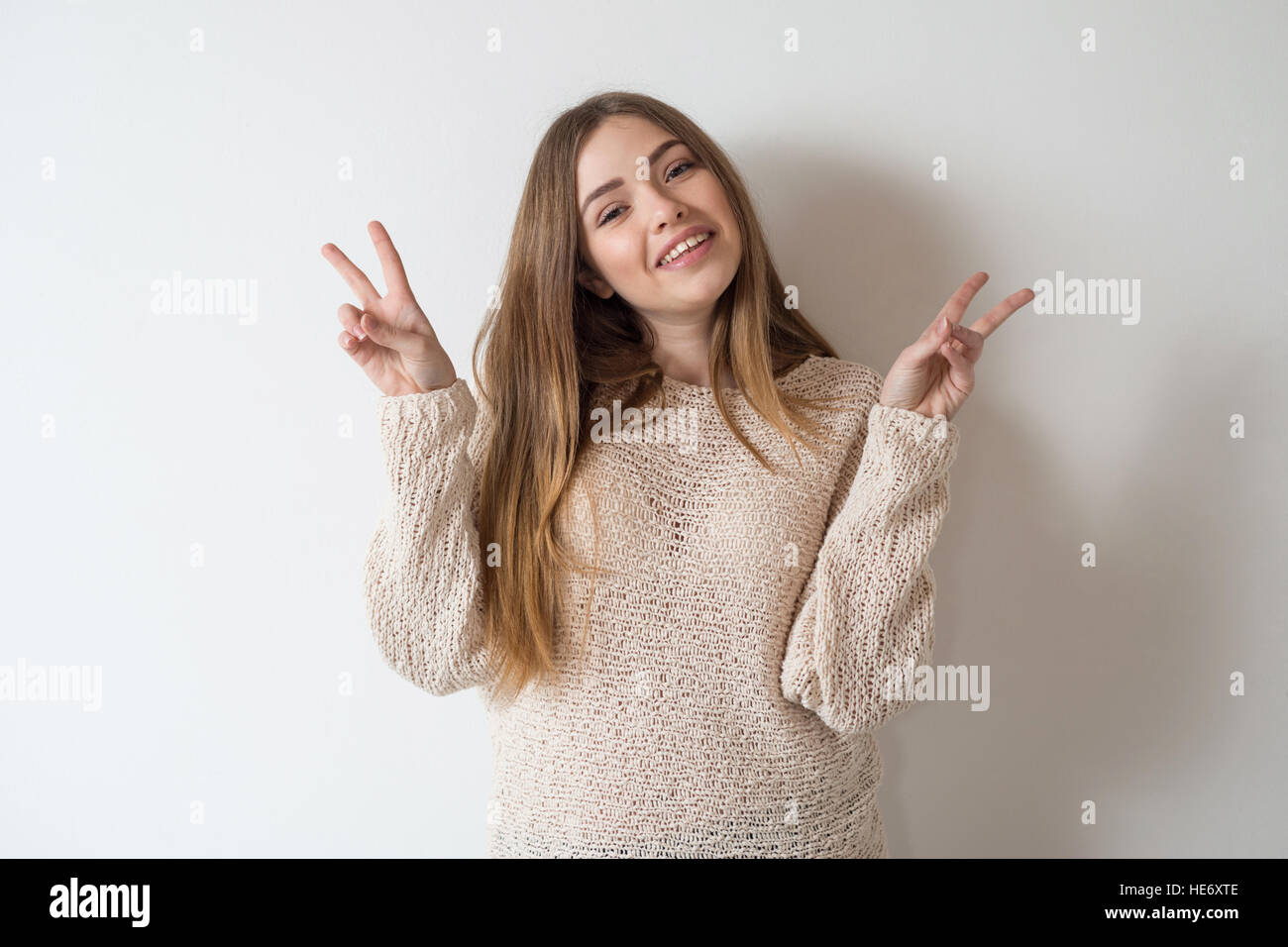 Funny girl showing the peace sign Stock Photo - Alamy