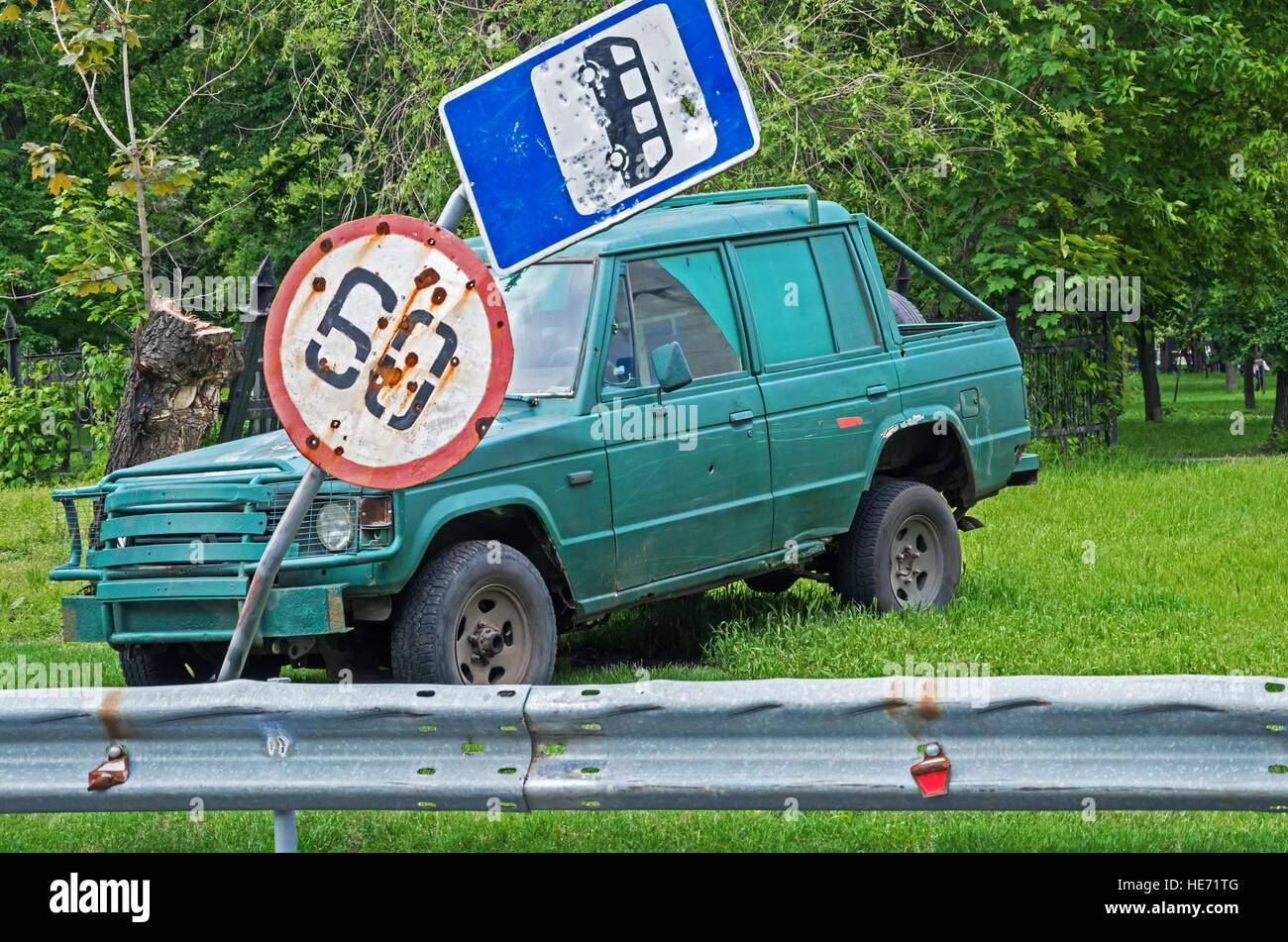 Damaged road signs on background old broken car Stock Photo - Alamy