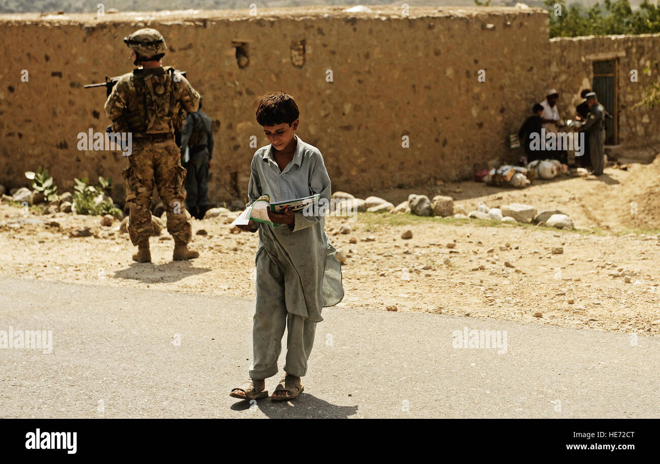 An Afghan child looks through an Afghan magazine handed out by the ...