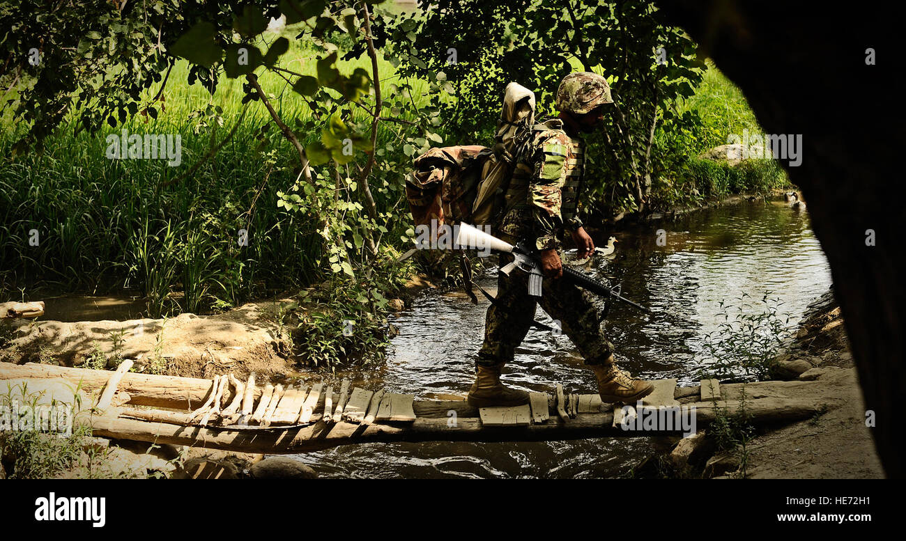 An Afghan National Army soldier crosses a makeshift bridge during a ...