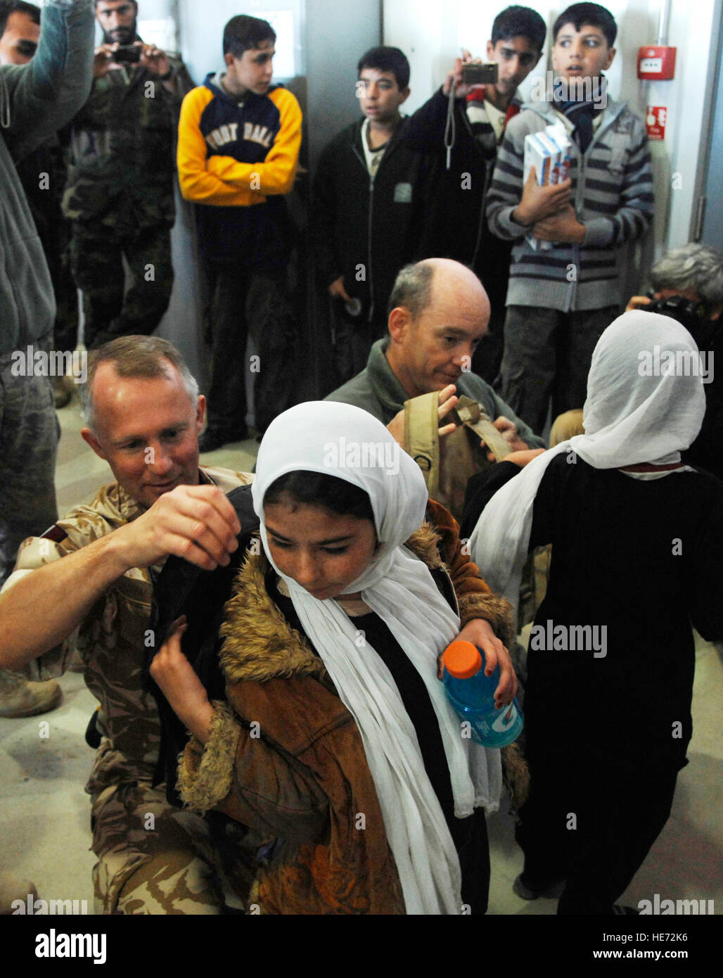 Air Commodore Malcolm Brecht, commander of Kandahar Airfield, assists a ...