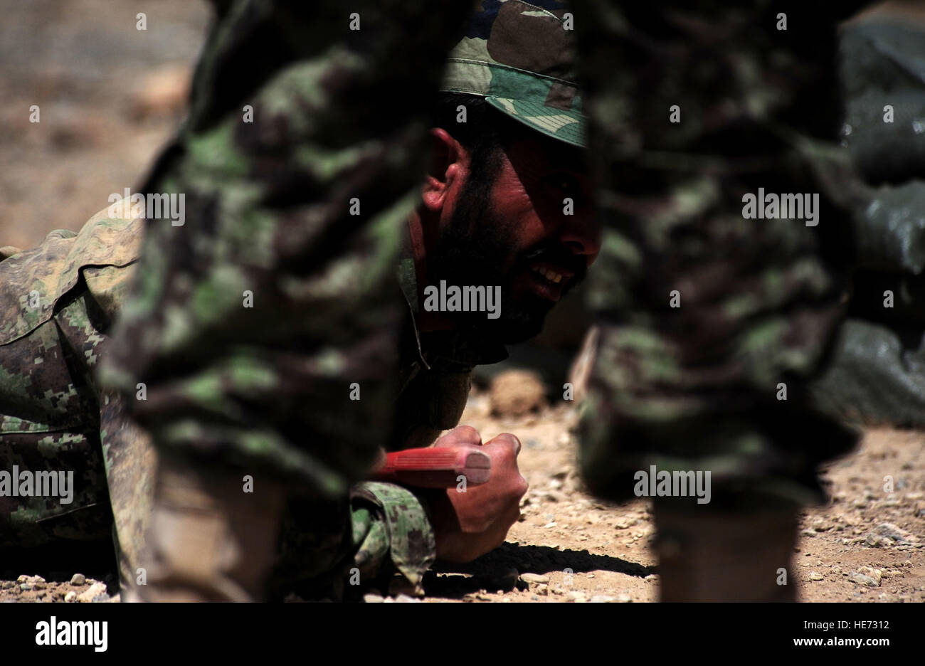 An Afghan National Army trainee perform a low crawl during a combat ...