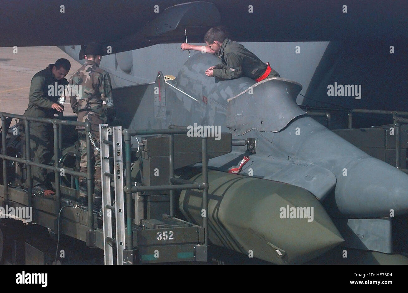 Munitions personnel, on a B-52 pylon maintenance/loading stand, from ...