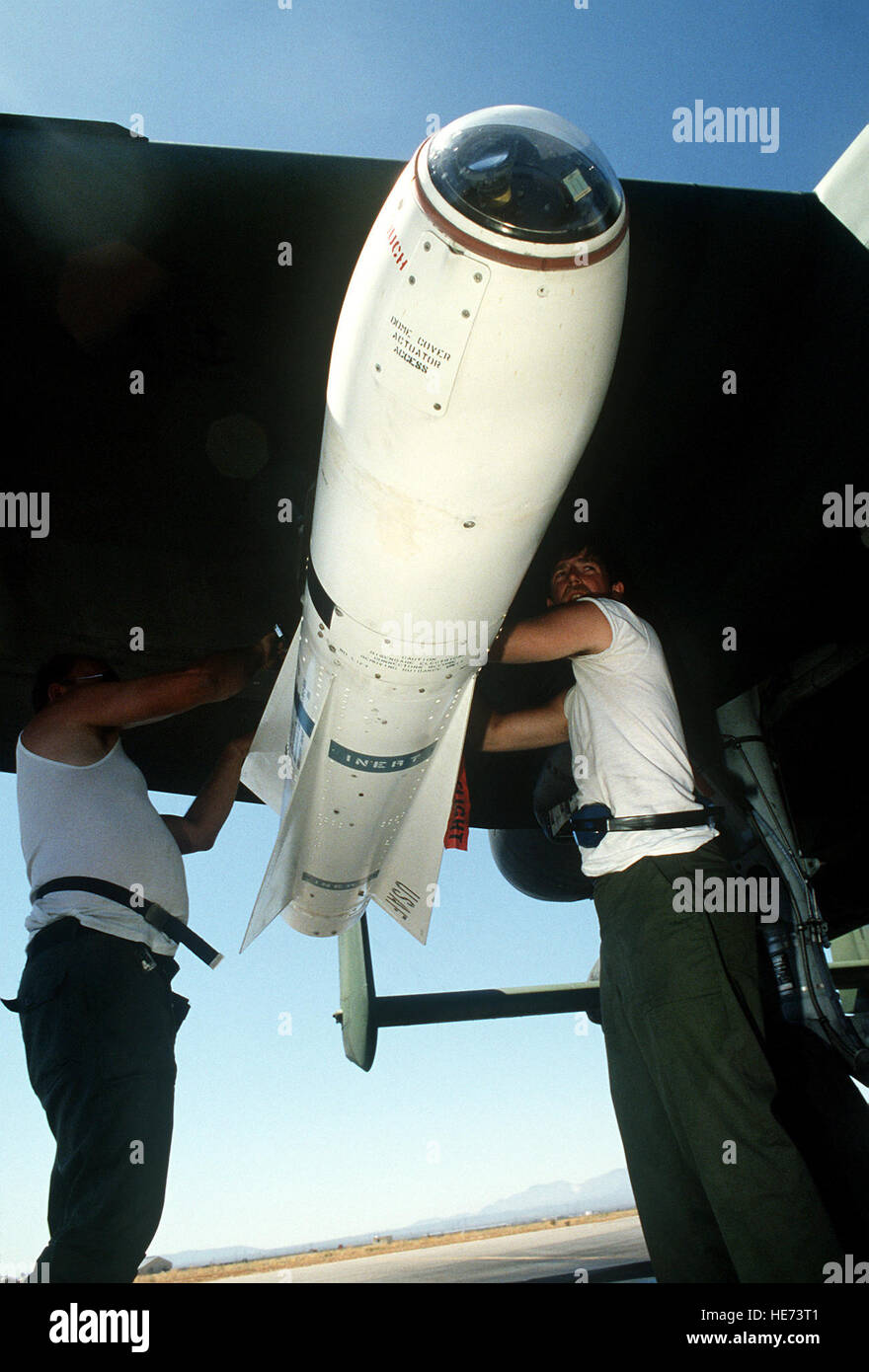 Sgt. Greg Lamontage and Airman 1st Class Rick Buettner attach a ...