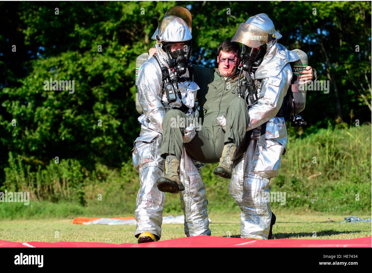 Firefighters from the 633rd Civil Engineer Squadron carry a simulated ...
