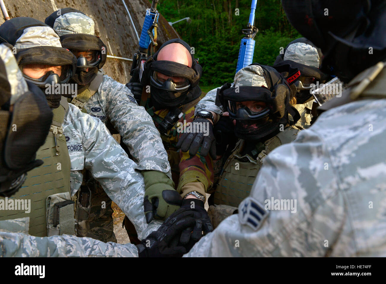 A group of U.S. Airmen and a German soldier huddle together before they ...