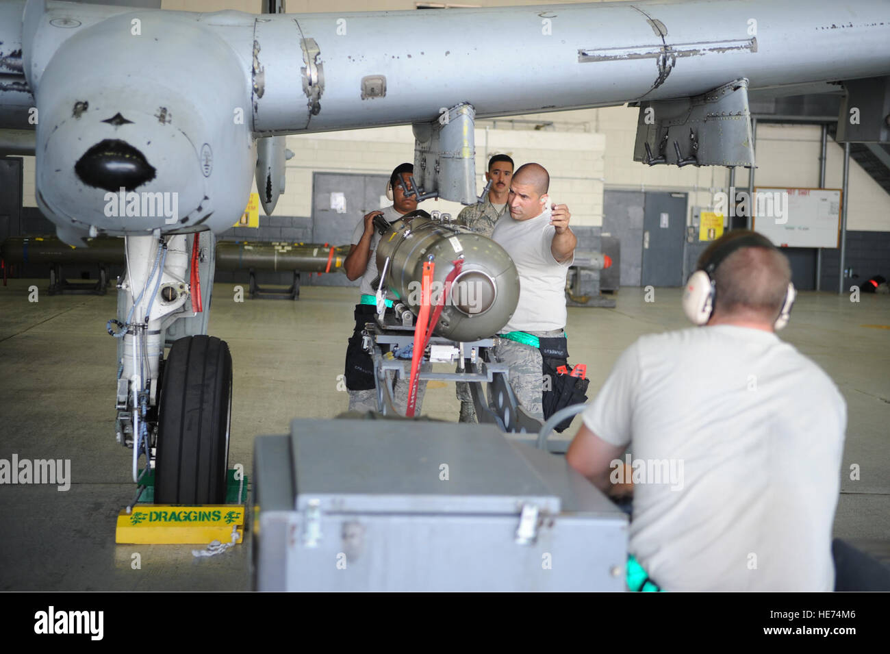 The 25th Aircraft Maintenance Unit weapons load crew team loads a bomb ...