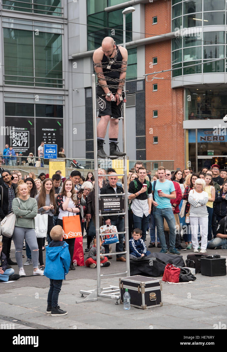 Street art performer on the stairs performing his show with people ...