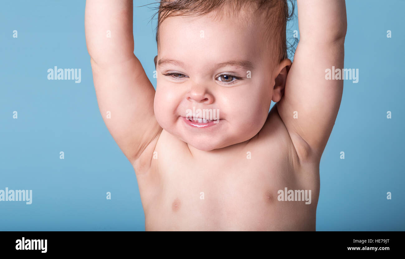 Joyful Toddler Girl with Raised Arms Against Blue Background Stock ...