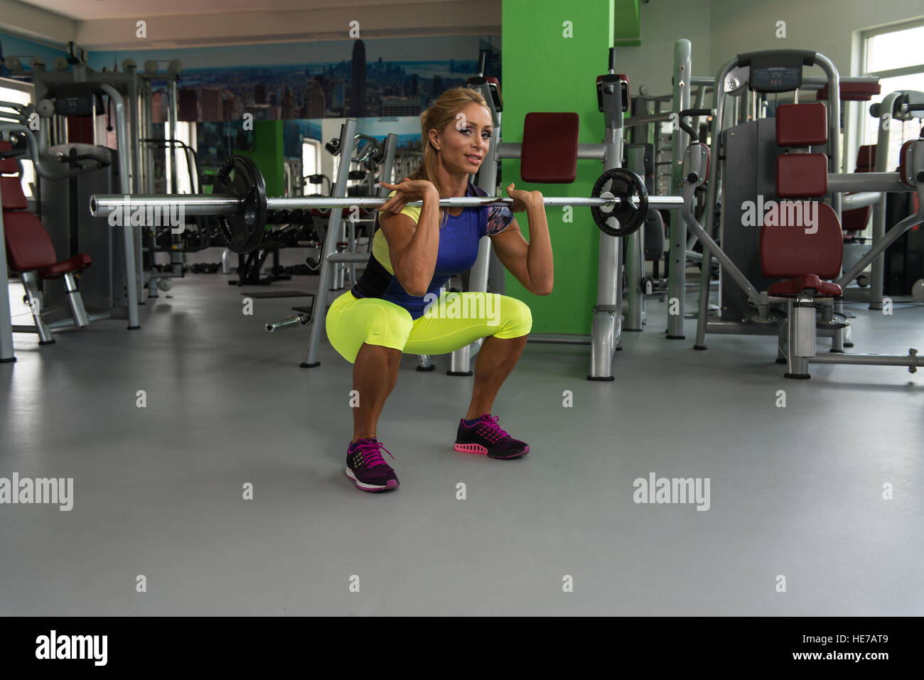 Mature Woman Working Out Legs With Barbell In A Gym - Squat Exercise ...