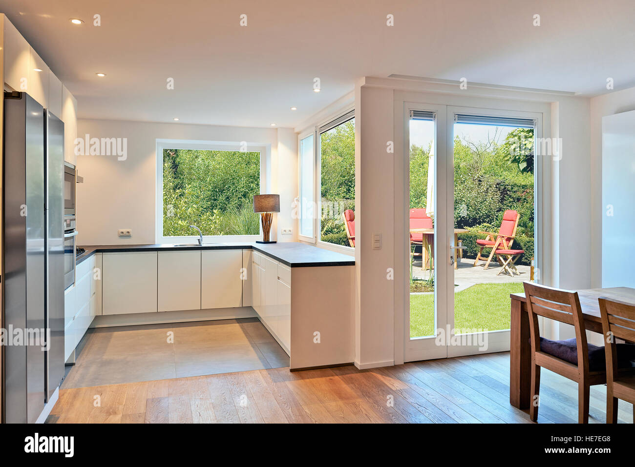 modern kitchen in renovated house with view on dining table with chairs ...