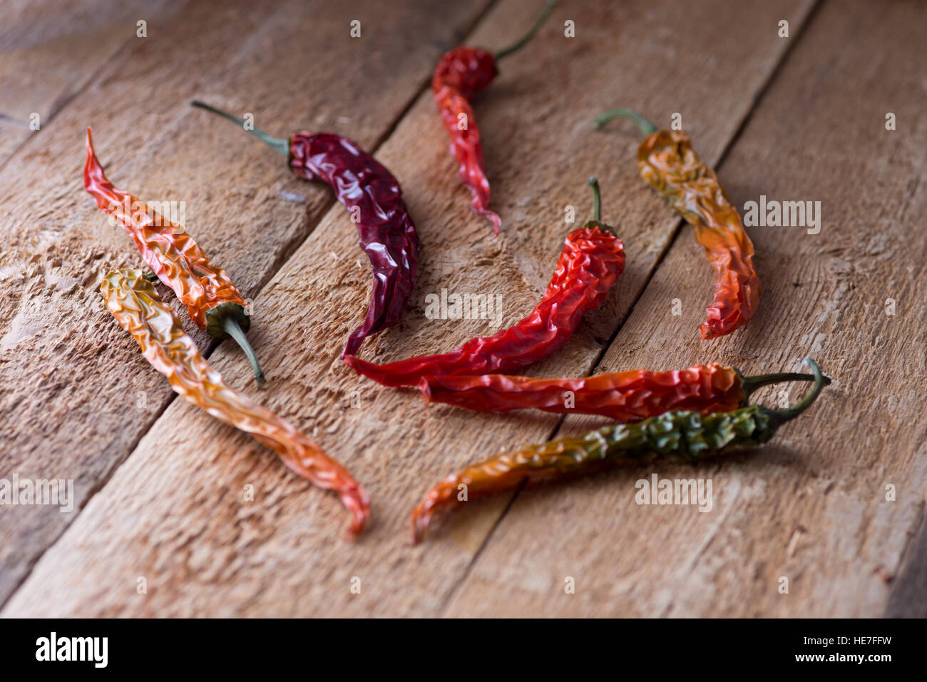 Colorful chili peppers on an aged wood background in rustic style Stock ...