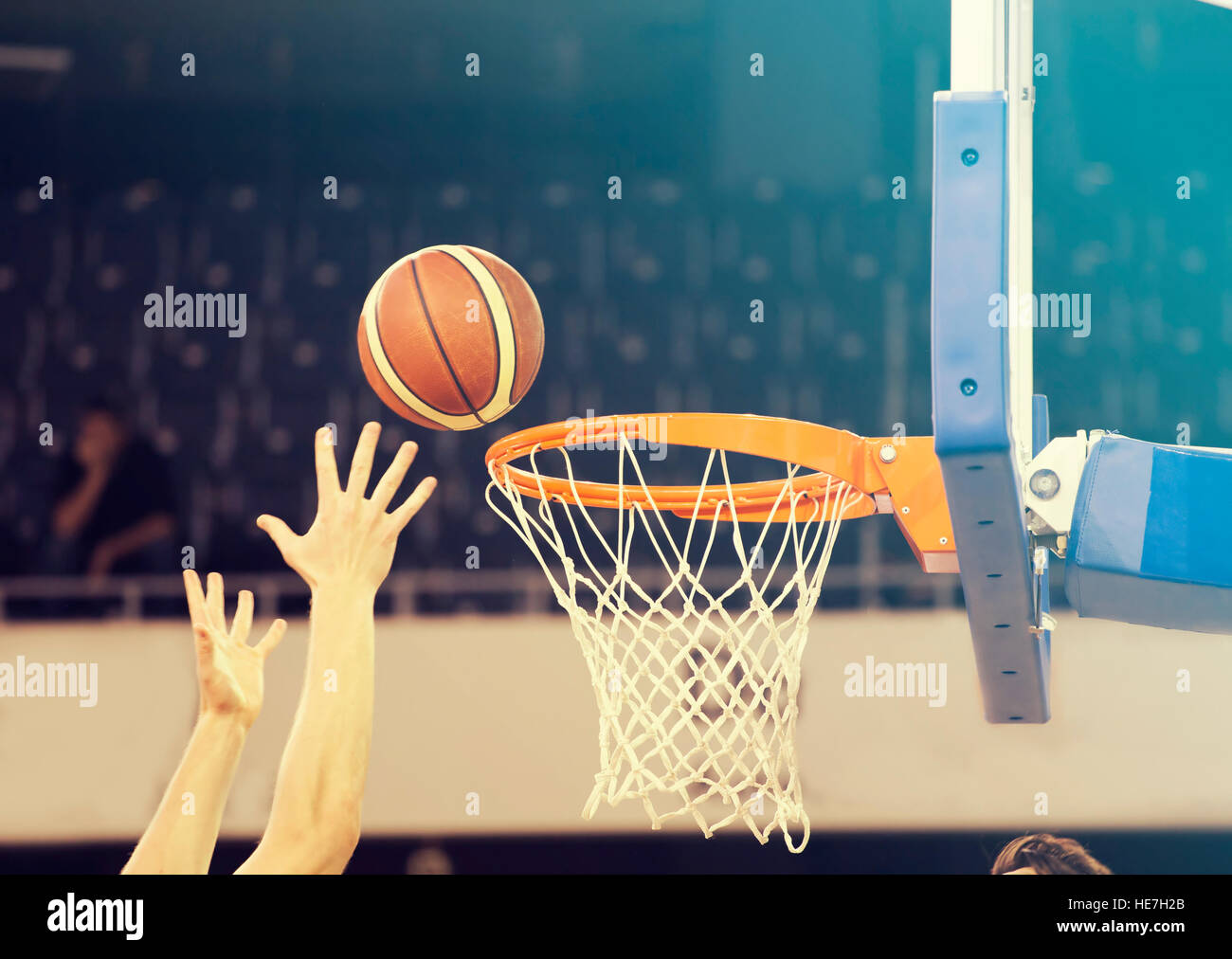 Ball in hoop at basketball game. Basketball players hands Stock Photo ...