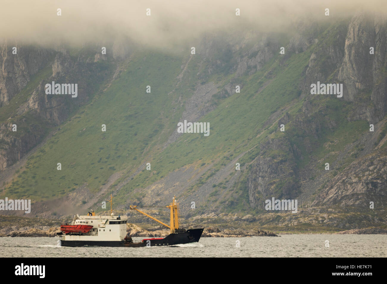Ship beneath a big mountain at Lofoten Islands, Norway Stock Photo - Alamy