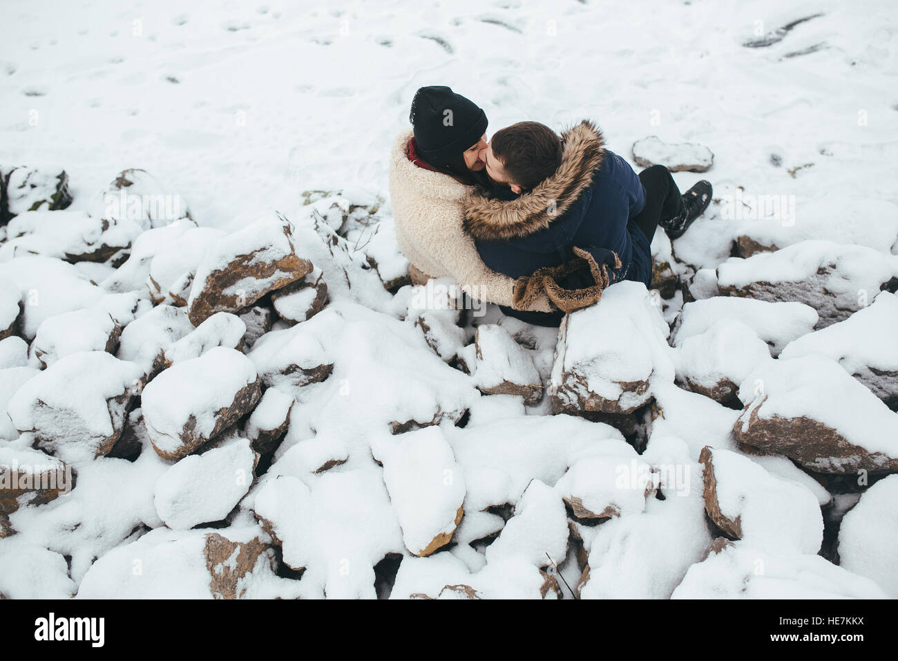 man and woman sitting on the snow-covered rocks Stock Photo - Alamy