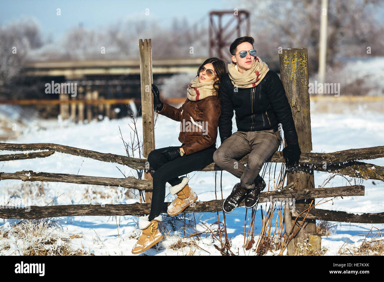 young couple sitting on old fence Stock Photo - Alamy