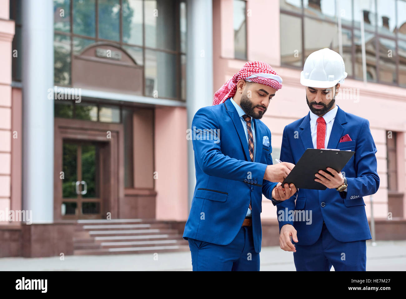 Your signature please. Portrait of a Saudi businessman signing papers ...