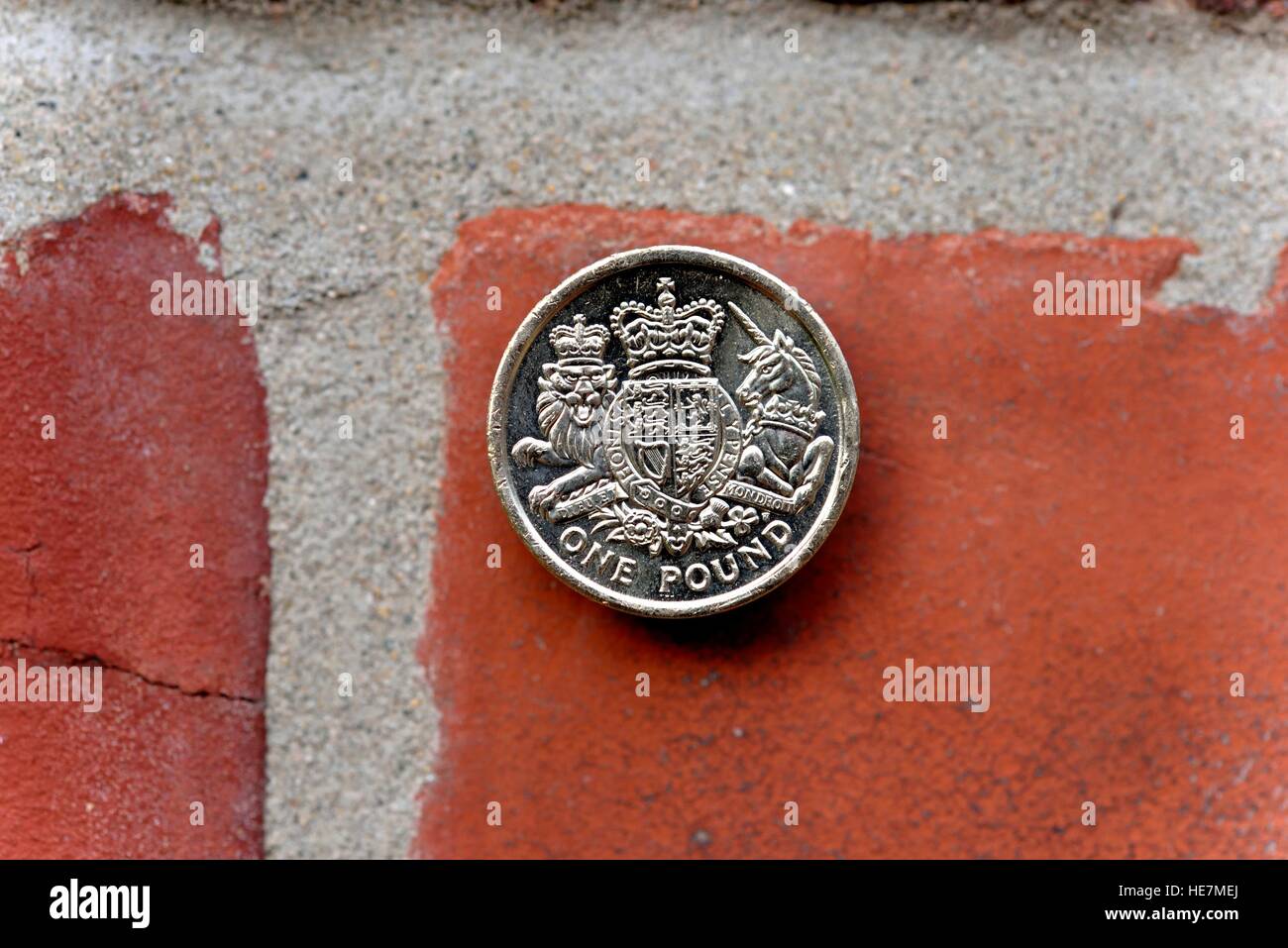 A one pound coin attached to a house brick Stock Photo - Alamy