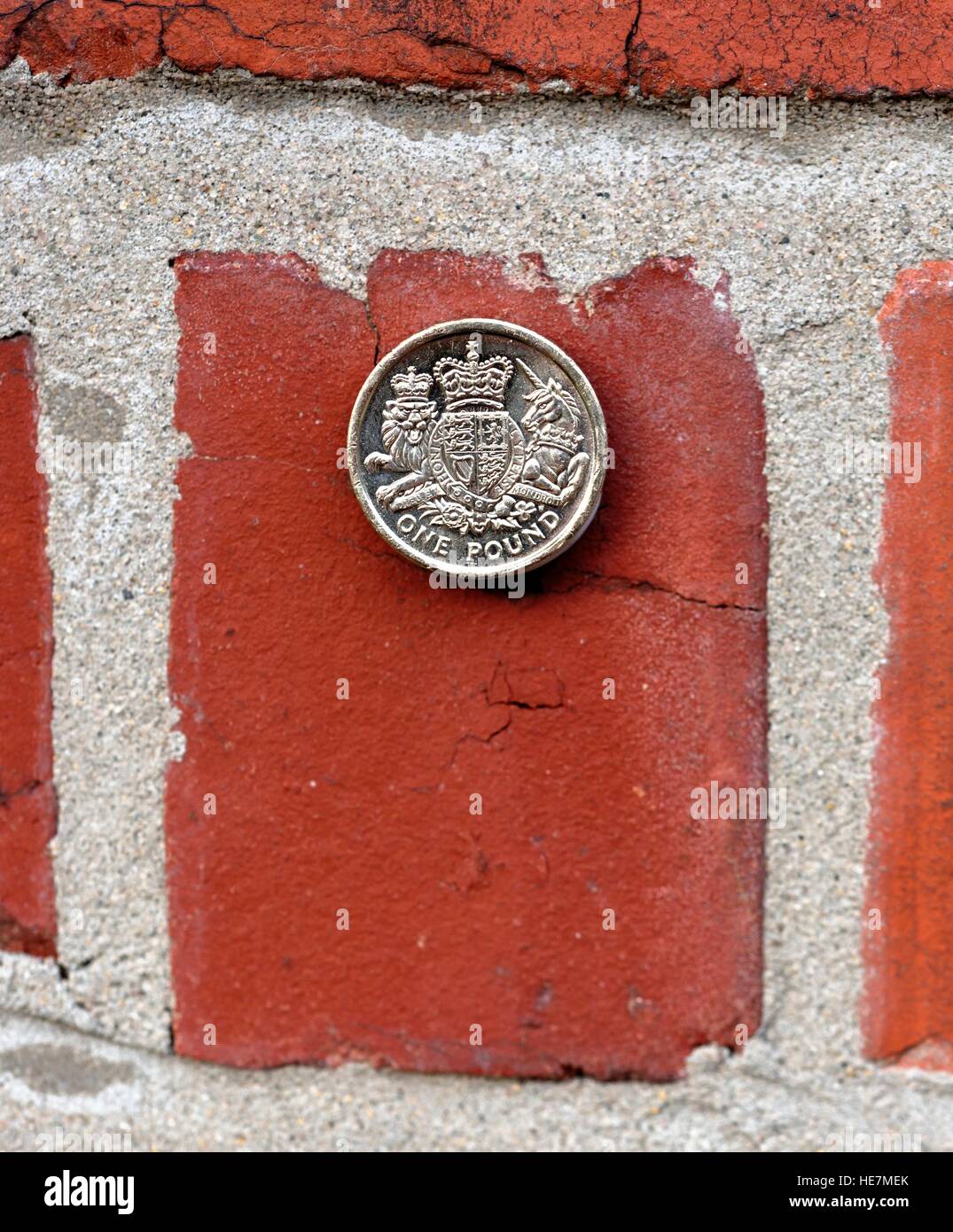 A one pound coin attached to a house brick Stock Photo - Alamy