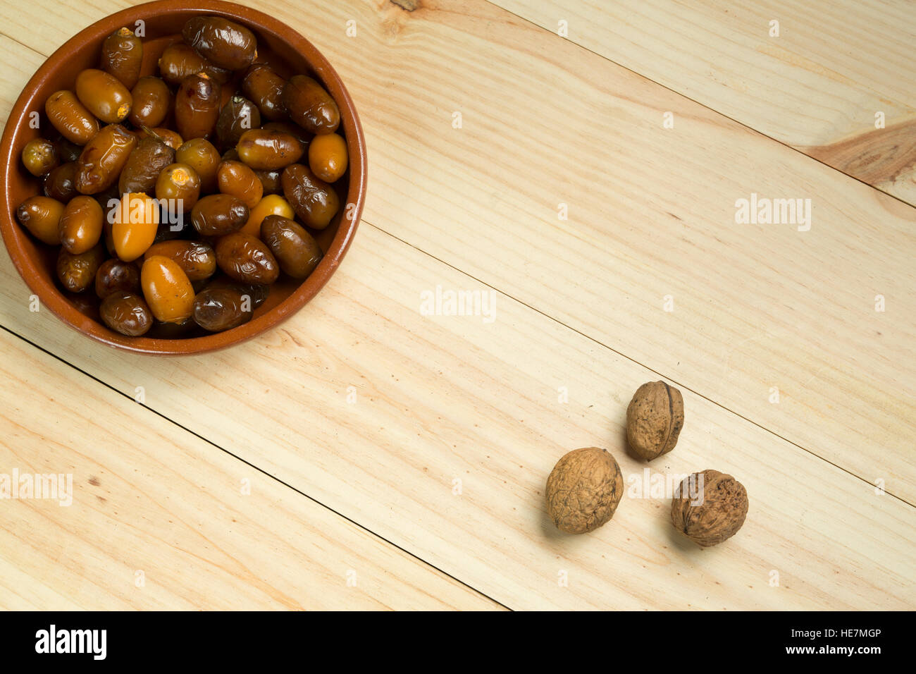 Dice and nuts on a background of pine wood. Artificial lighting with ...