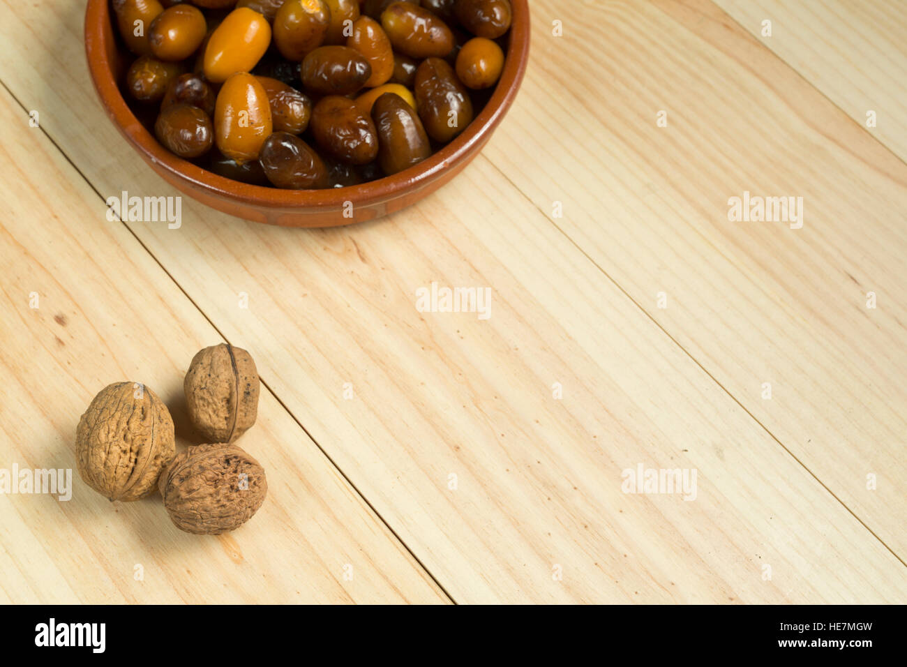 Dice and nuts on a background of pine wood. Artificial lighting with ...