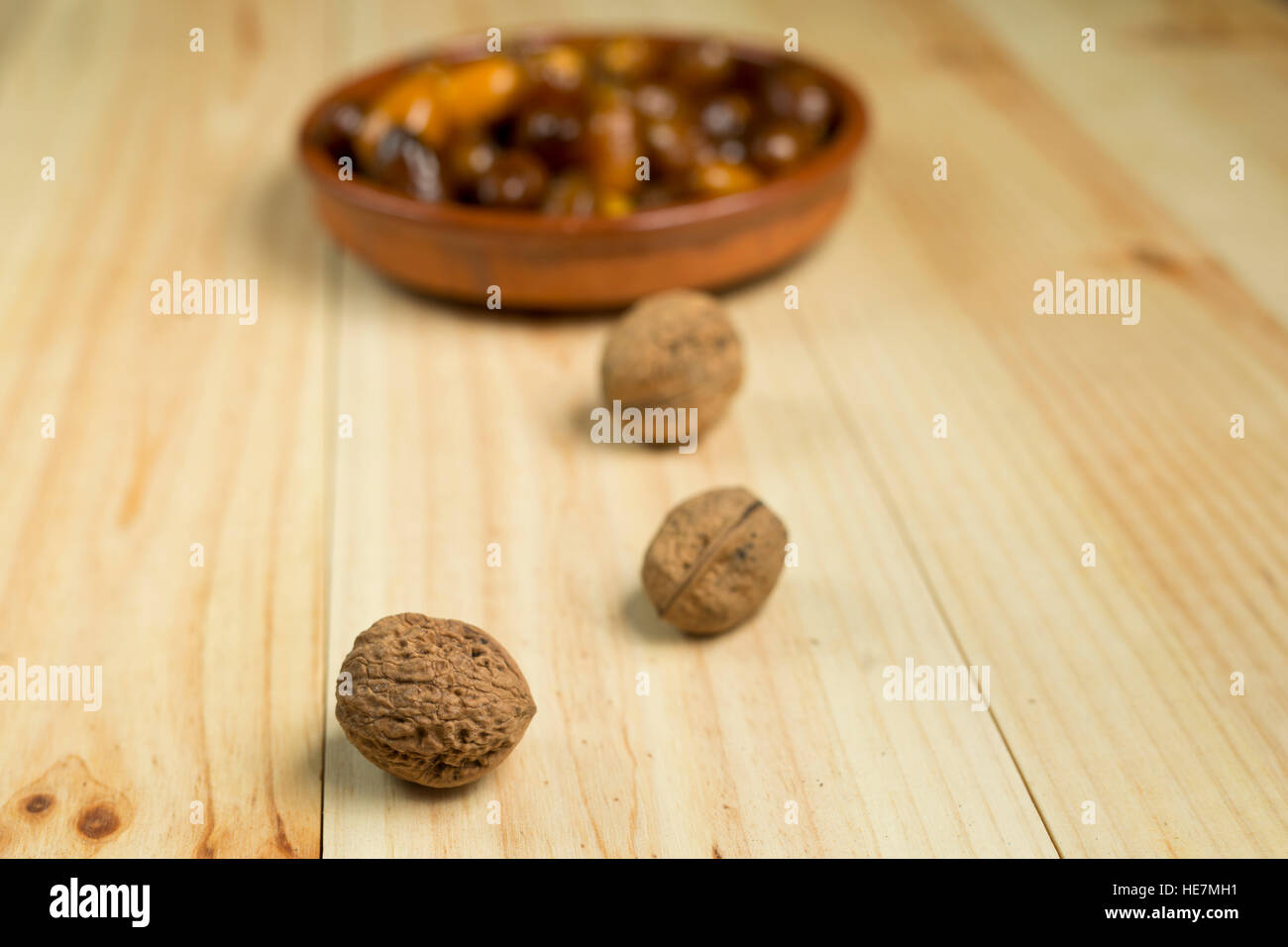 Dice and nuts on a background of pine wood. Artificial lighting with ...