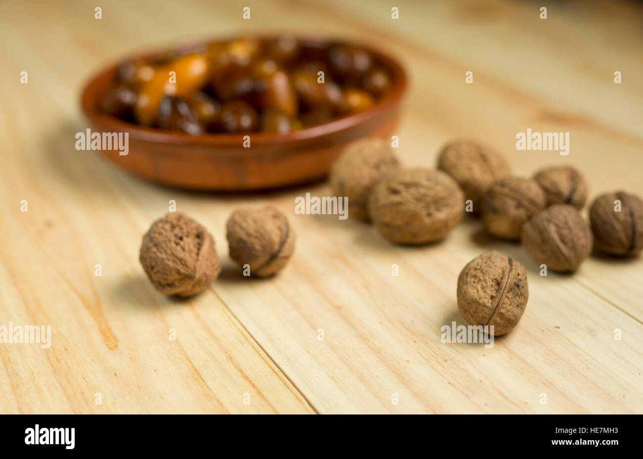 Dice and nuts on a background of pine wood. Artificial lighting with ...