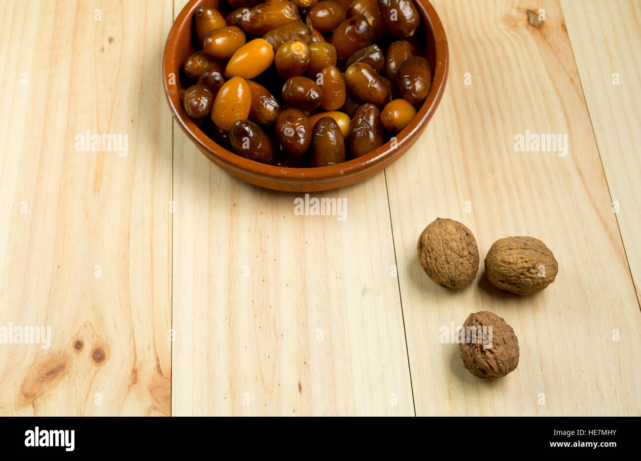 Dice and nuts on a background of pine wood. Artificial lighting with ...