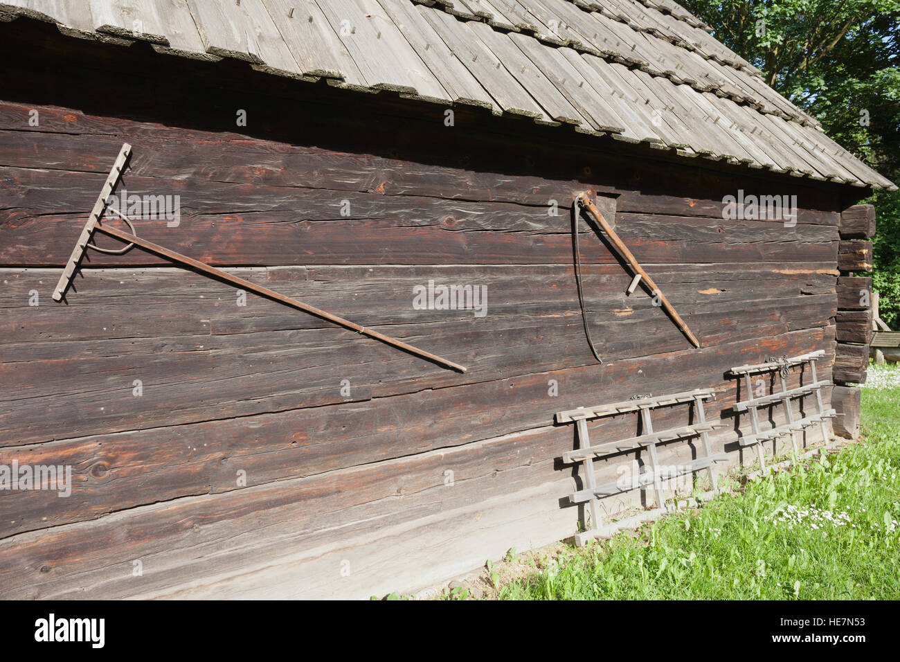 Traditional handmade rake and scythe on barn wall, Ethnographic Park ...