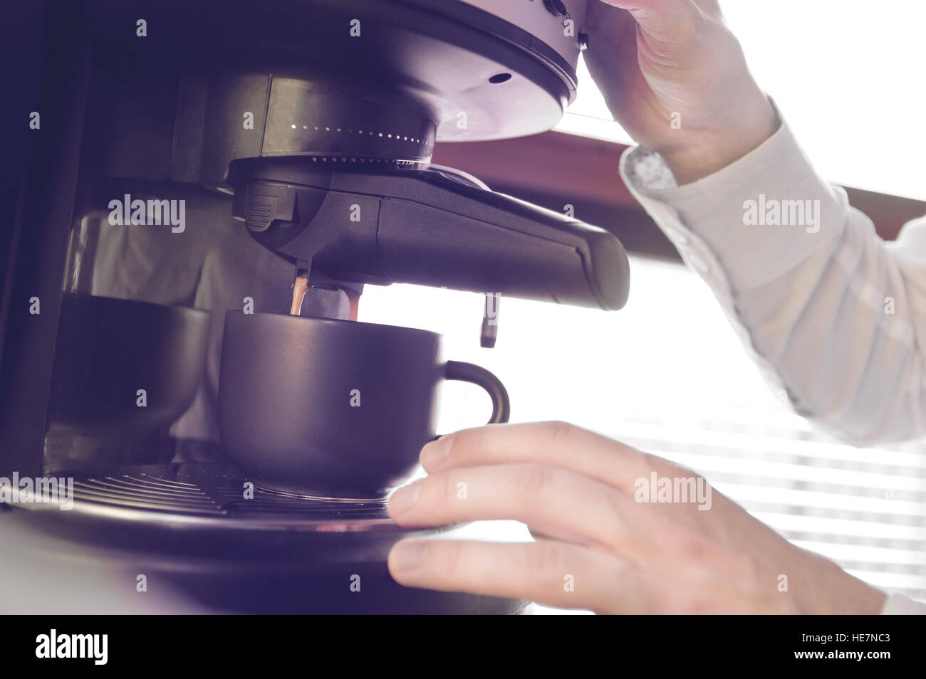 Man is making morning coffee in coffee machine. Retro photo effects ...