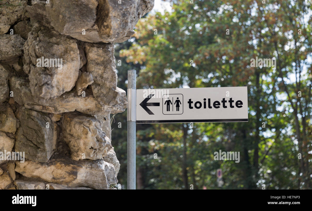 Toilet direction sign on white plate closeup outdoor Stock Photo - Alamy