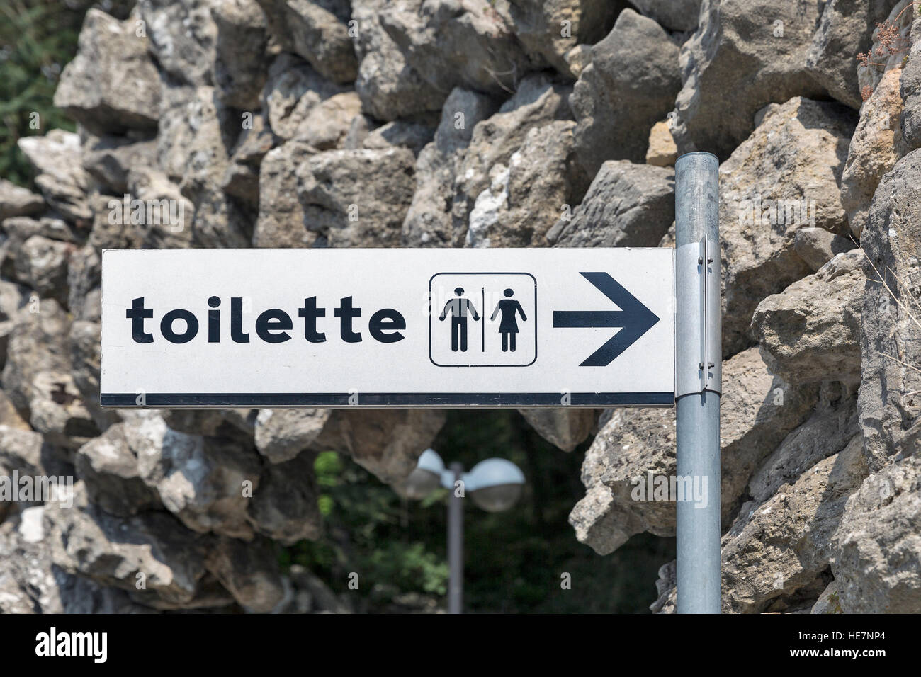 Toilet direction sign on white plate closeup outdoor Stock Photo - Alamy