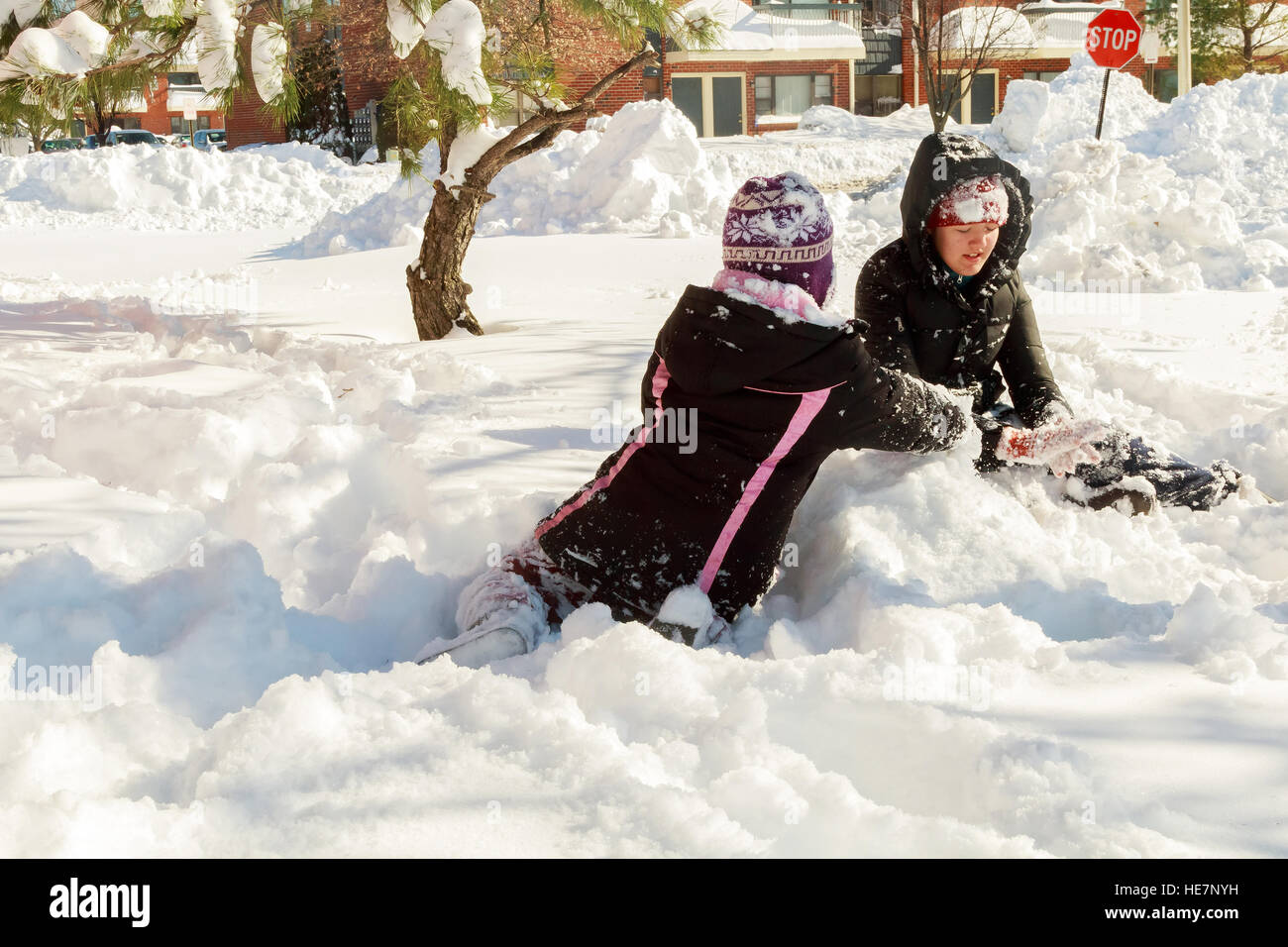 two little girls playing on the snow children play in winter with snow ...