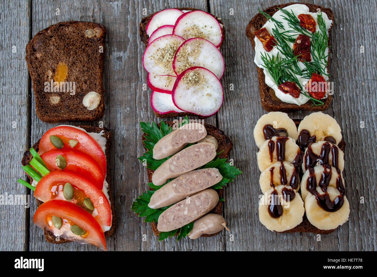 Top view of open sandwiches. Bread with nuts, bananas, berries, sausage ...