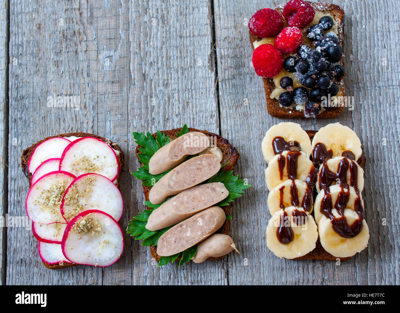 Top view of open sandwiches. Bread with nuts, bananas, berries, sausage ...
