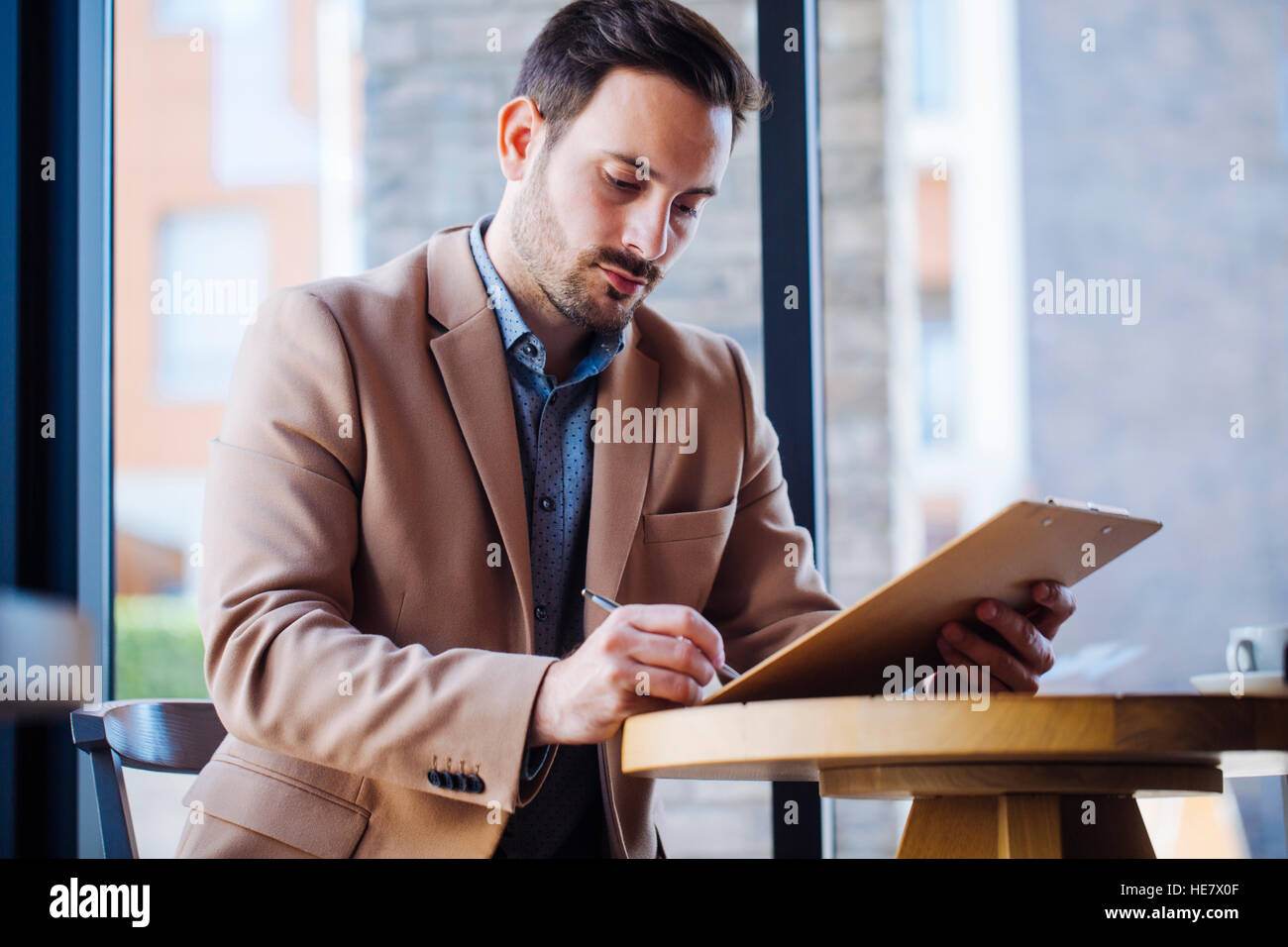 Handsome Businessman Writing in Coffee Shop Stock Photo - Alamy