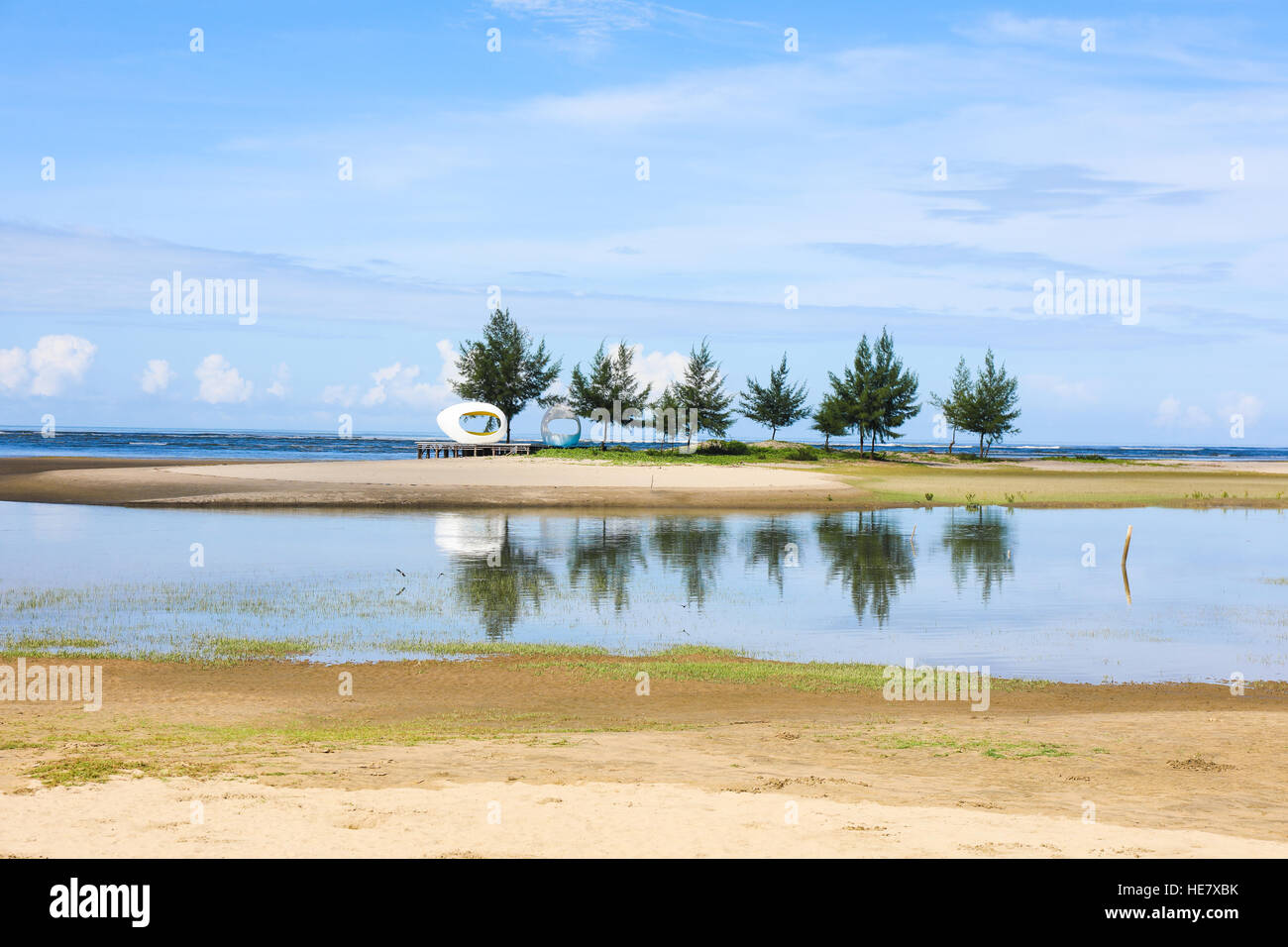 Small private island with some green trees under a bright blue skye ...