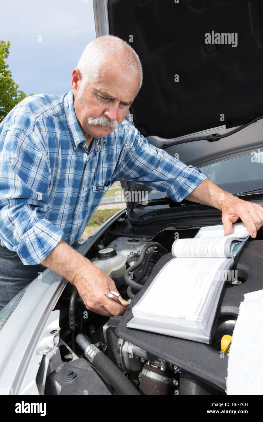 older man checking levels and servicing his car Stock Photo - Alamy